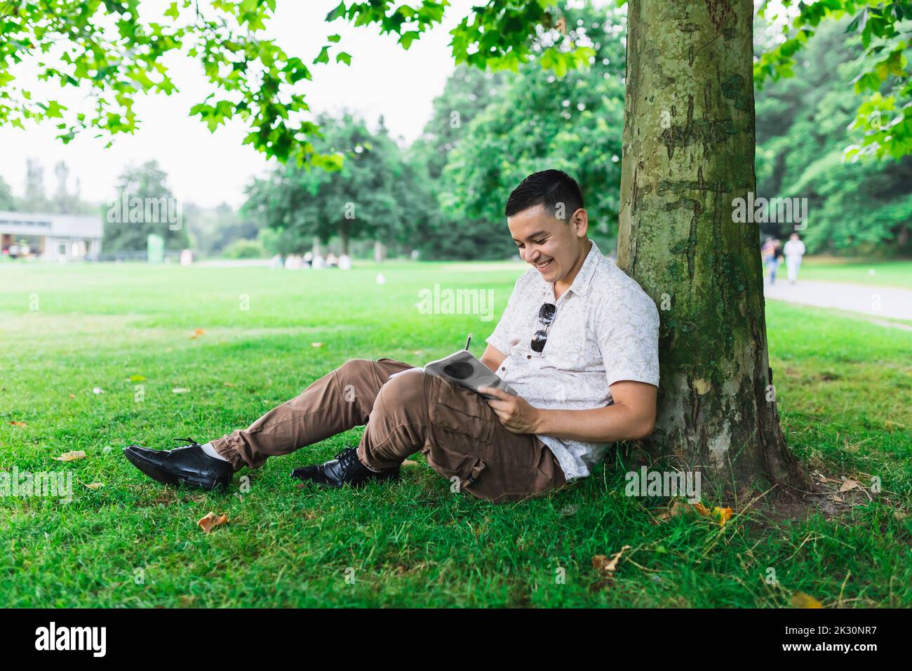 Reading by the tree hi-res stock photography and images - Alamy