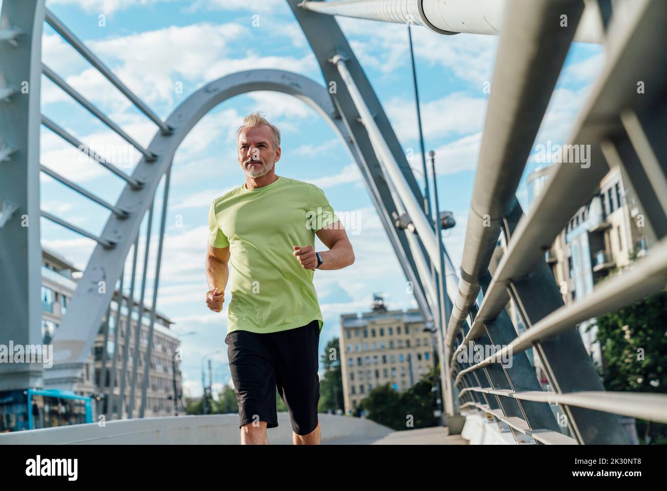 Man jogging on suspension bridge in city Stock Photo - Alamy