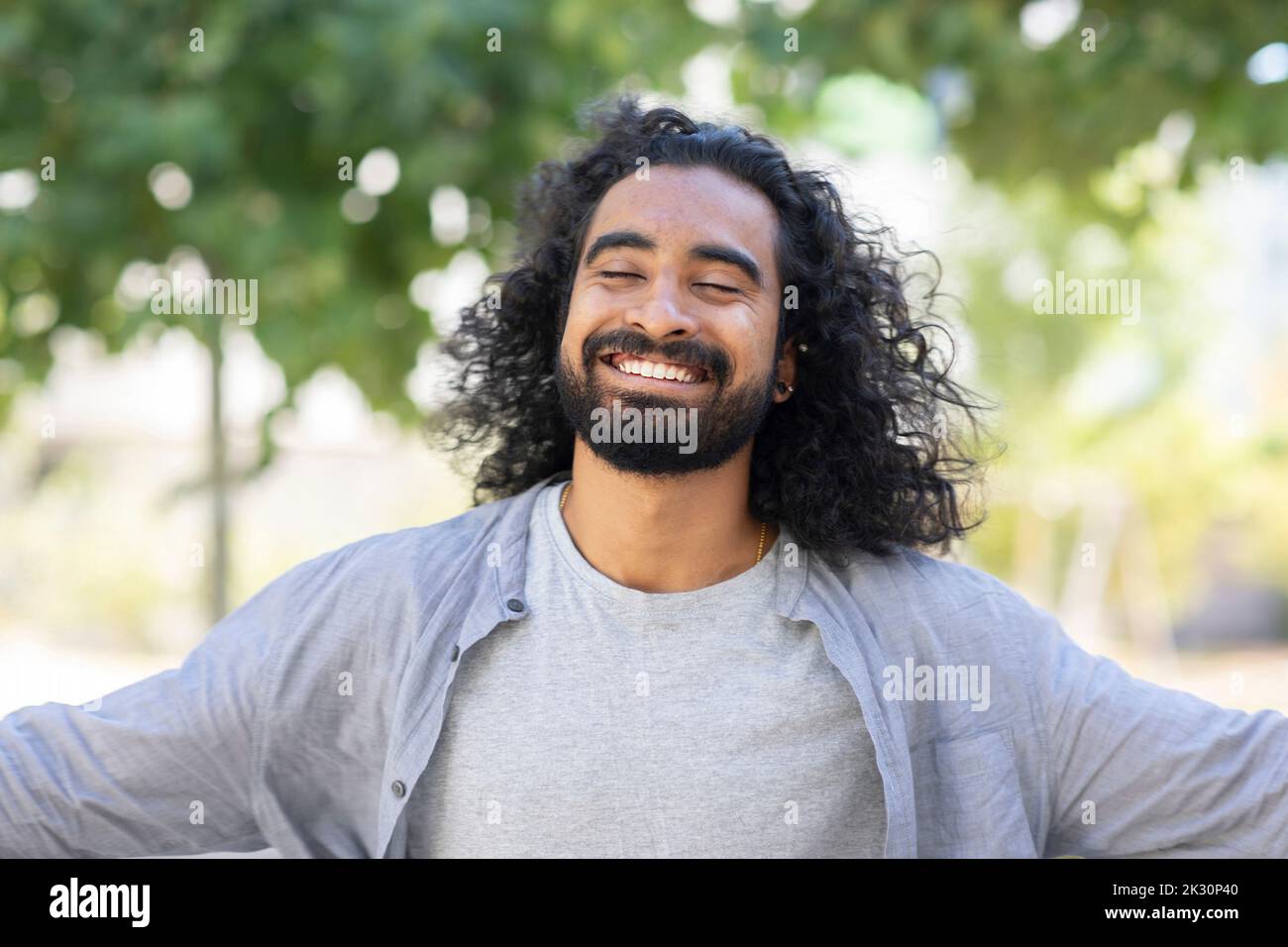 Happy bearded young man with long hair Stock Photo - Alamy