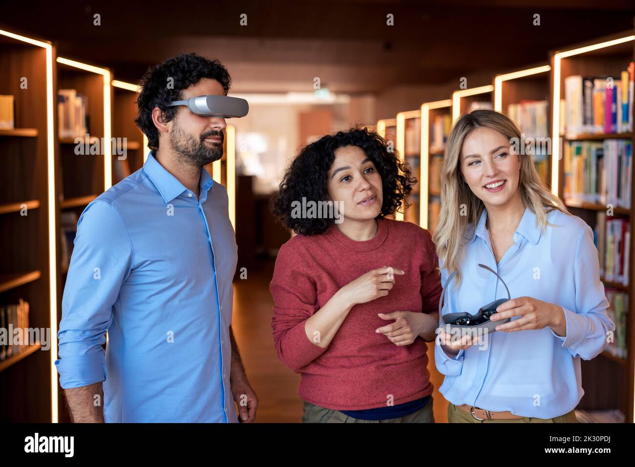 Professor watching through smart glasses standing by colleagues in ...