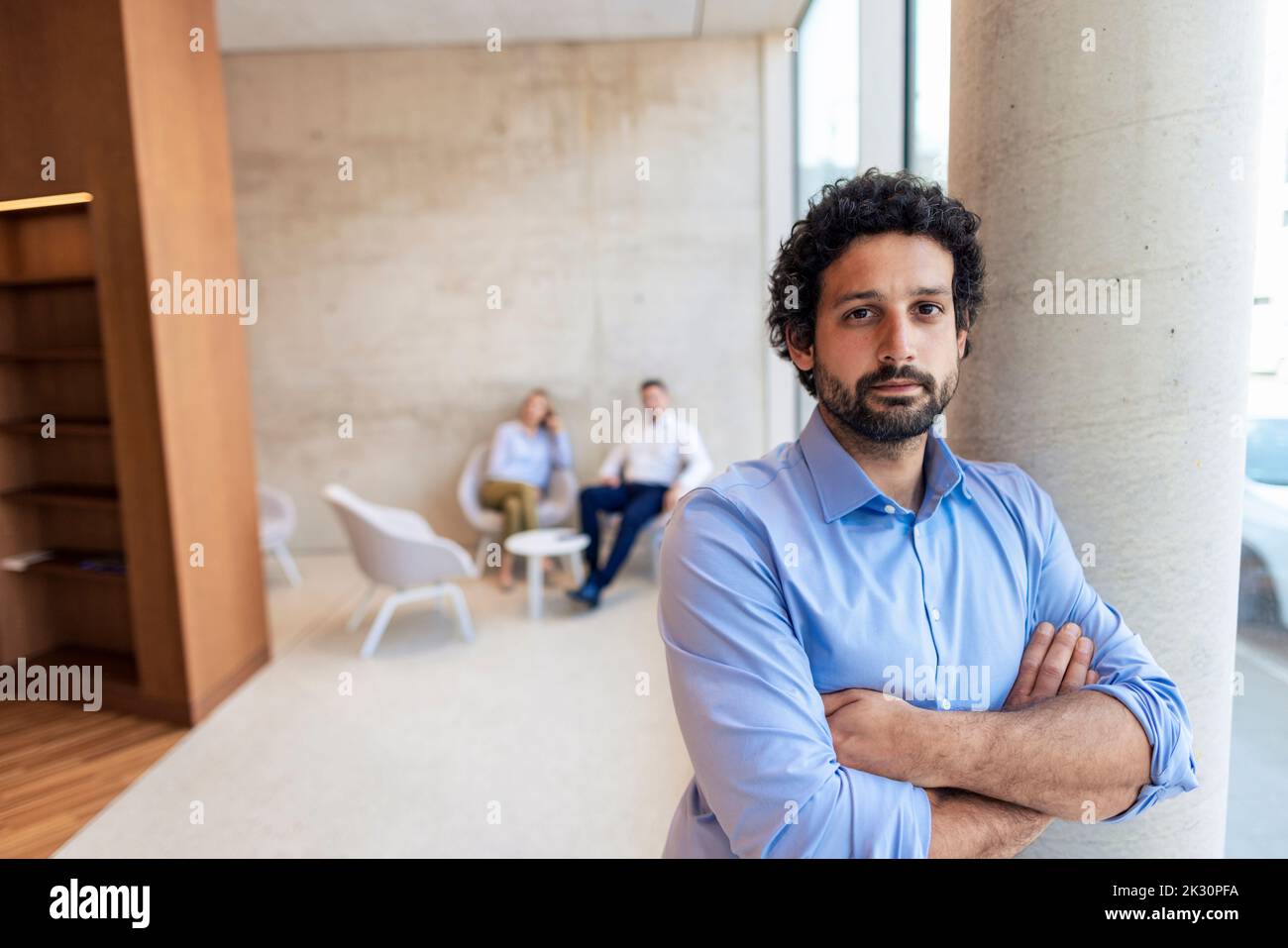Confident professor with arms crossed leaning on column Stock Photo - Alamy
