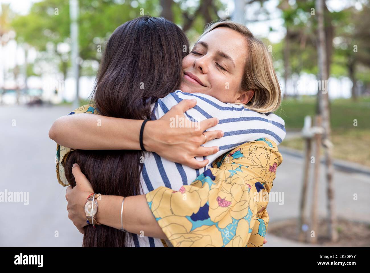 Two female friends hugging rear view hi-res stock photography and ...