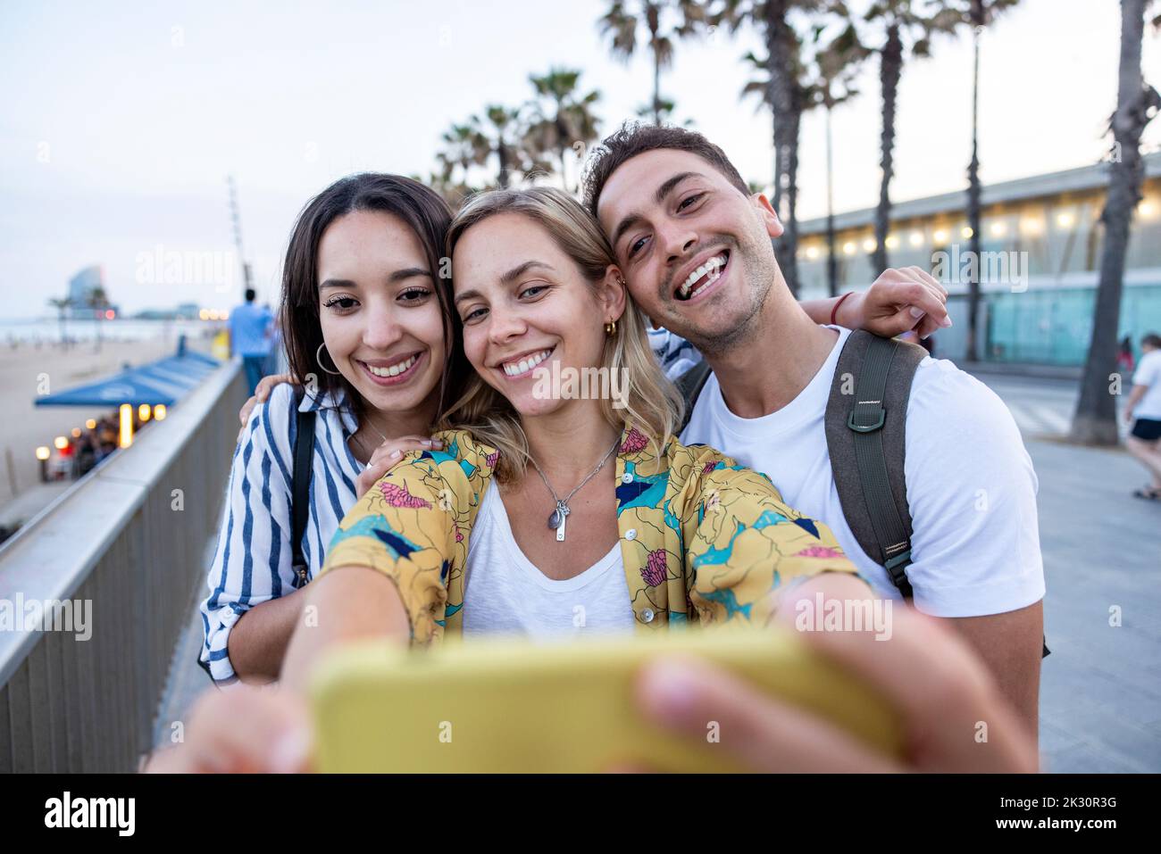 Happy young woman taking selfie with friends Stock Photo - Alamy