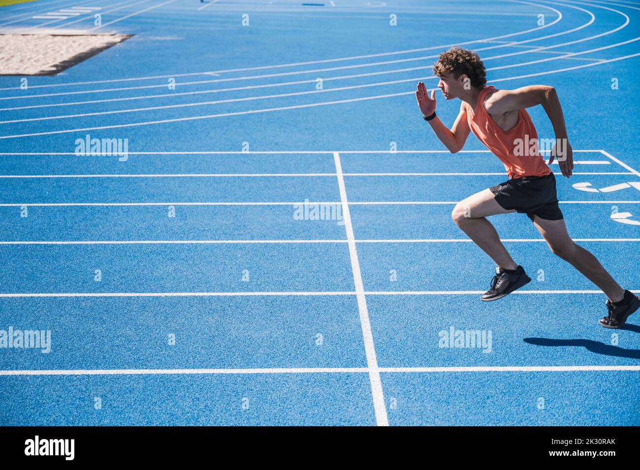 Young sportsman running on track Stock Photo - Alamy