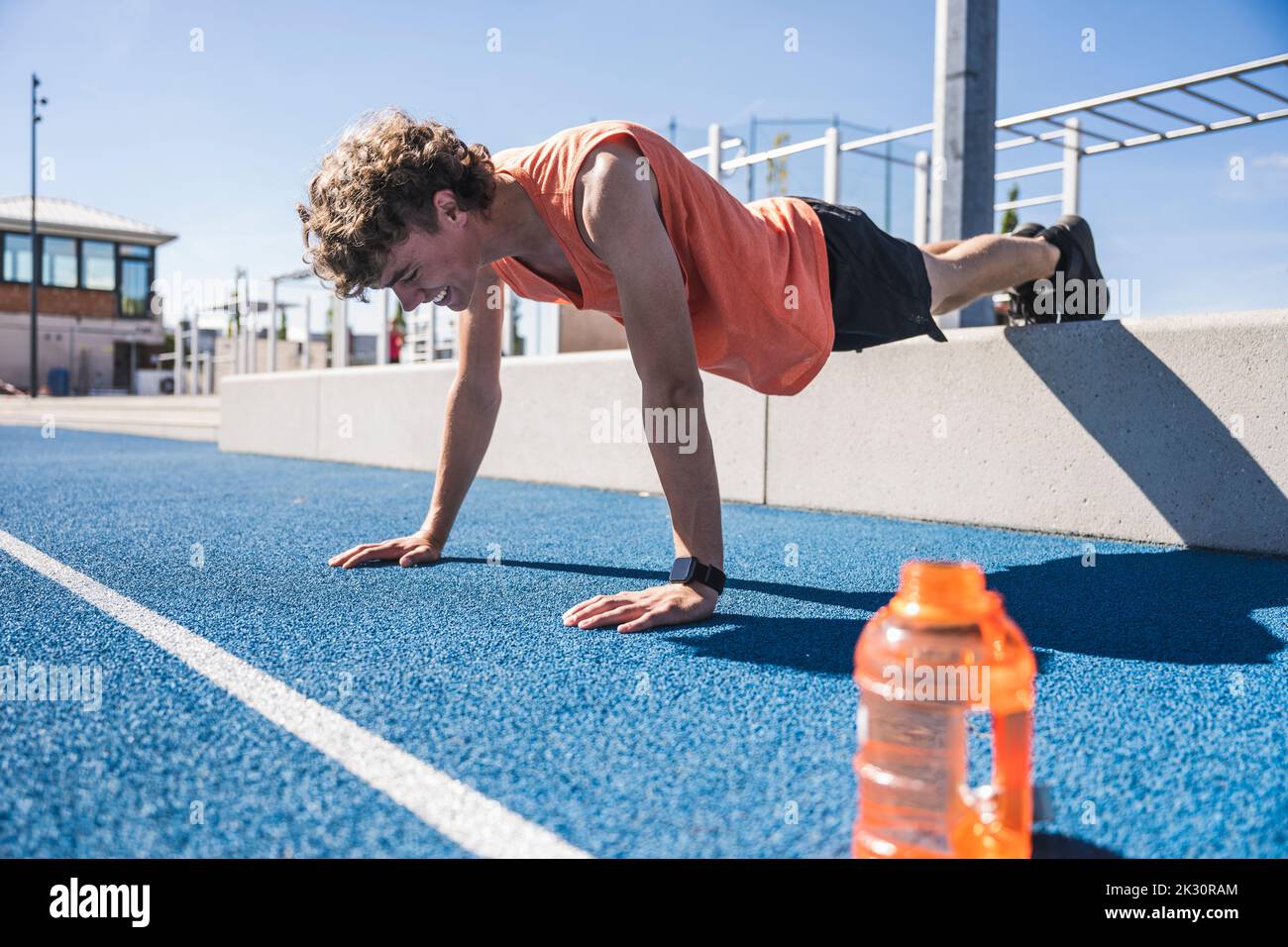 Happy sportsman doing push-ups on running track Stock Photo - Alamy