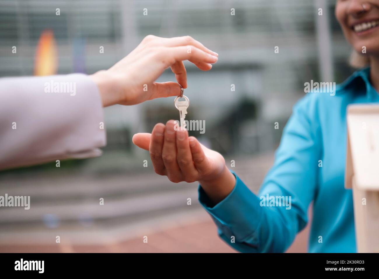 Hand of real estate agent giving house key to customer Stock Photo - Alamy