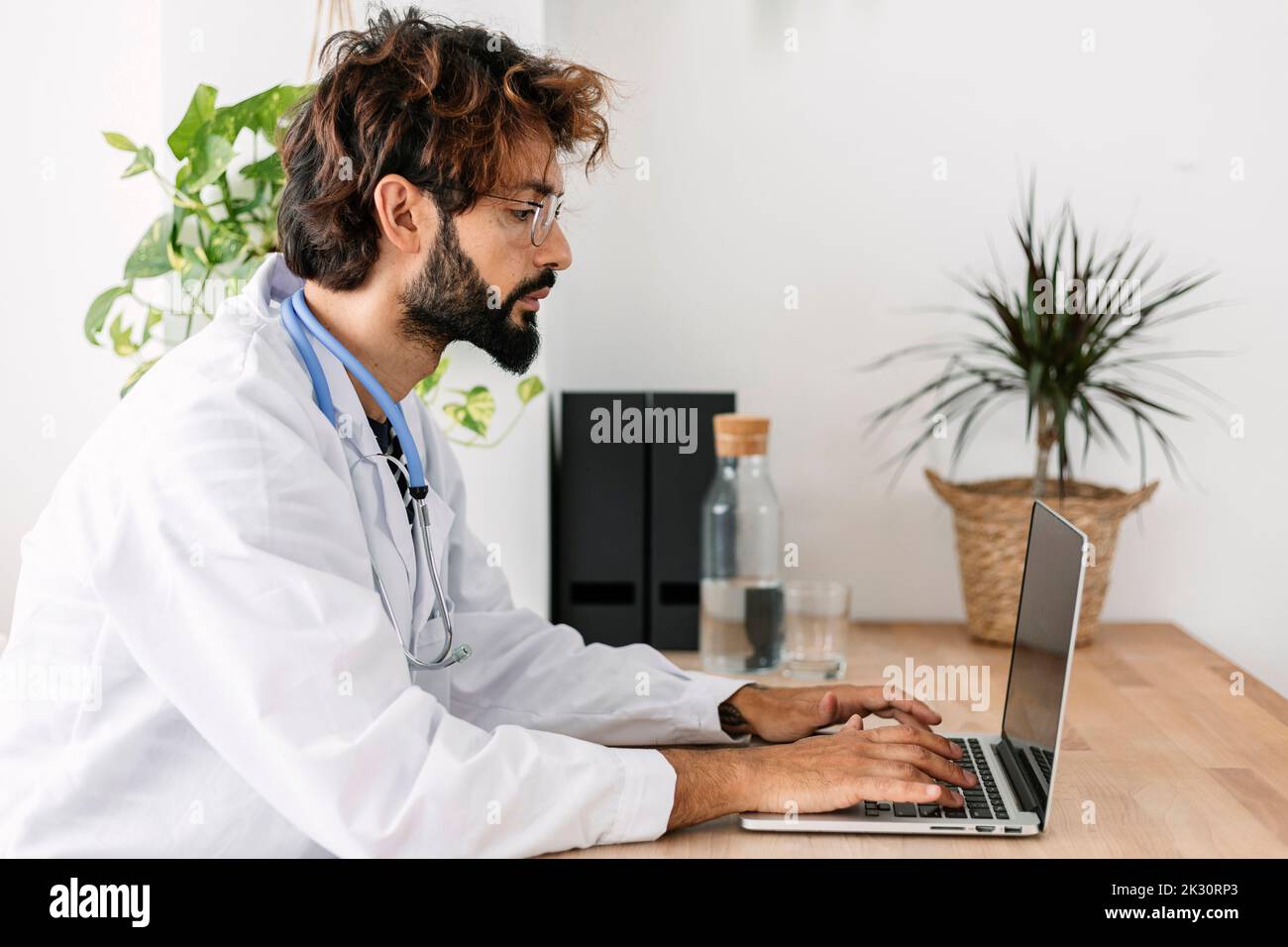 Doctor sitting desk working computer hi-res stock photography and ...
