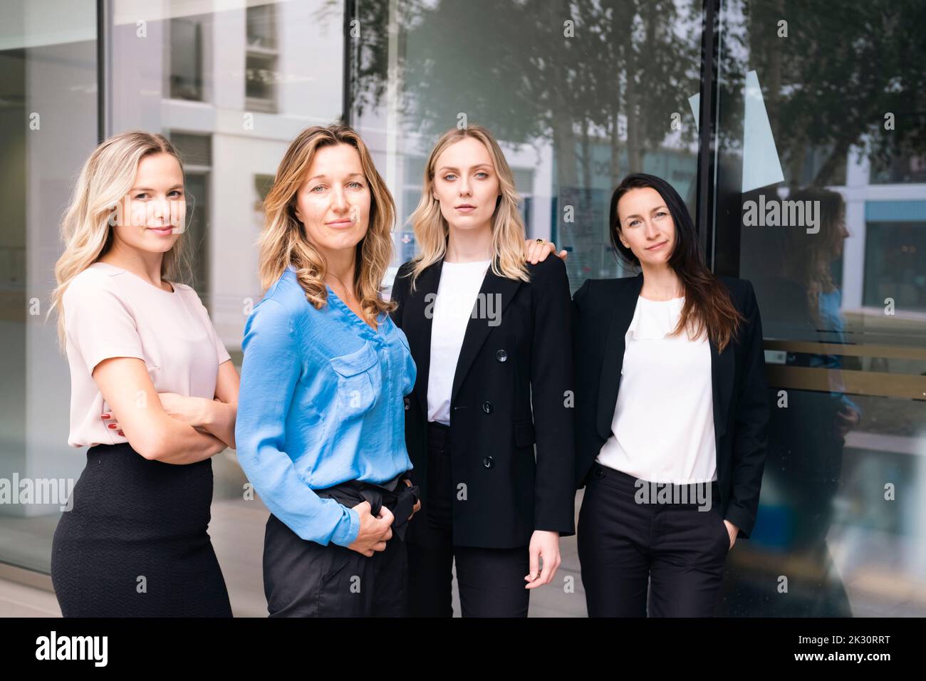 Business people standing together in front of glass wall Stock Photo ...