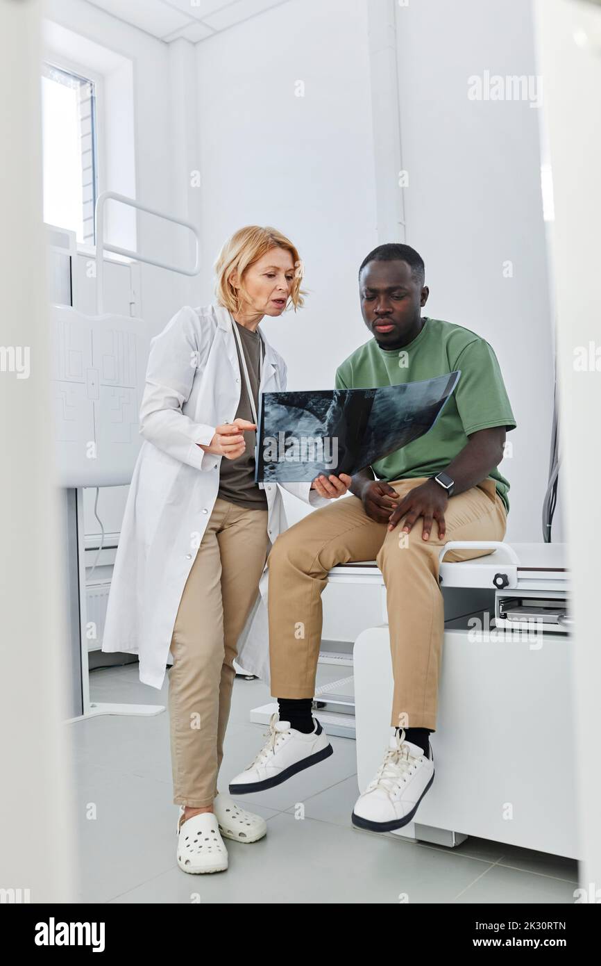 Doctor explaining X-ray to patient sitting in clinic Stock Photo - Alamy