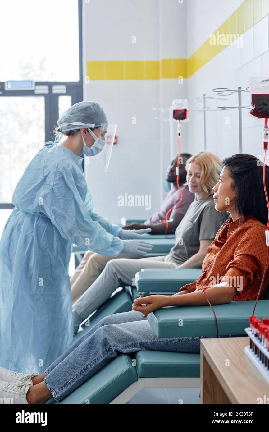 Nurse instructing woman donating blood in hospital Stock Photo - Alamy