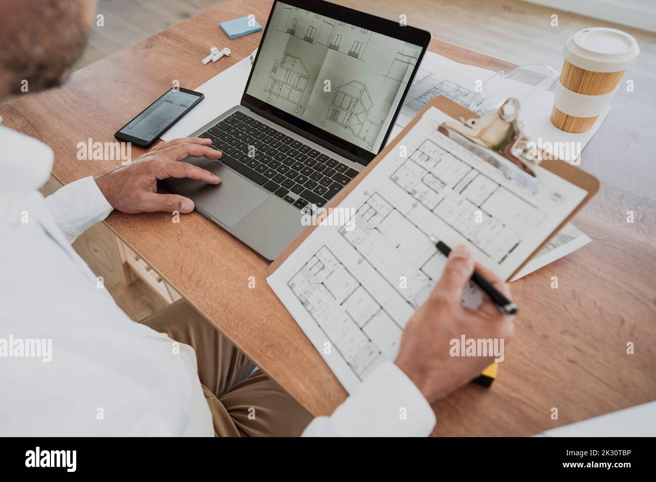 Architect with blueprint working at desk Stock Photo - Alamy