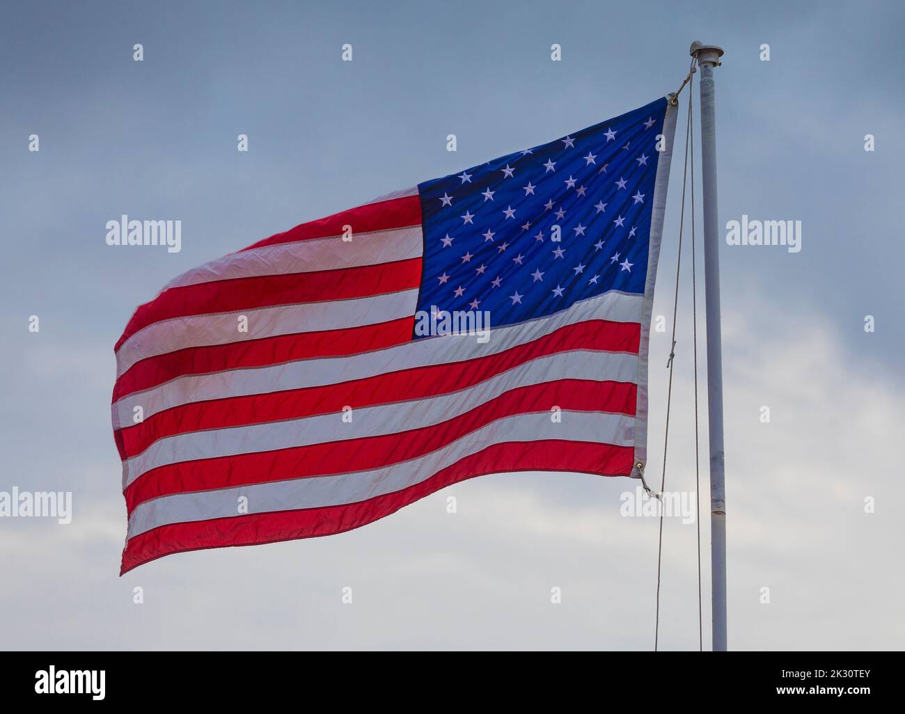 American flag proudly flying with motion blurd and clouds Stock Photo ...