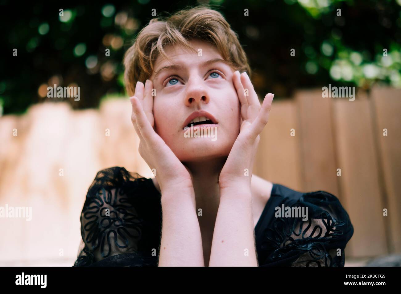Thoughtful non-binary person touching face Stock Photo - Alamy