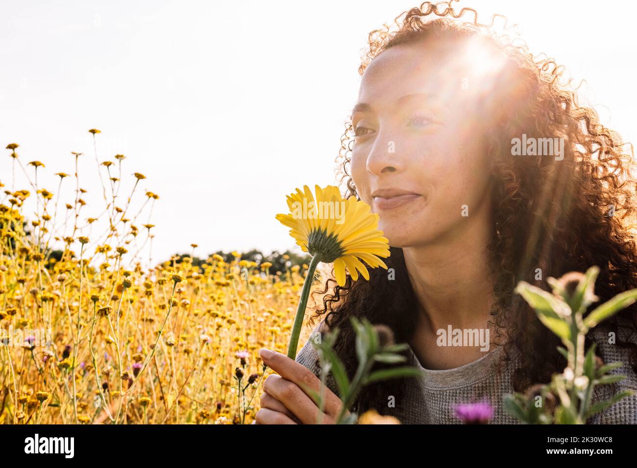 smiling woman smelling flower Stock Photo - Alamy