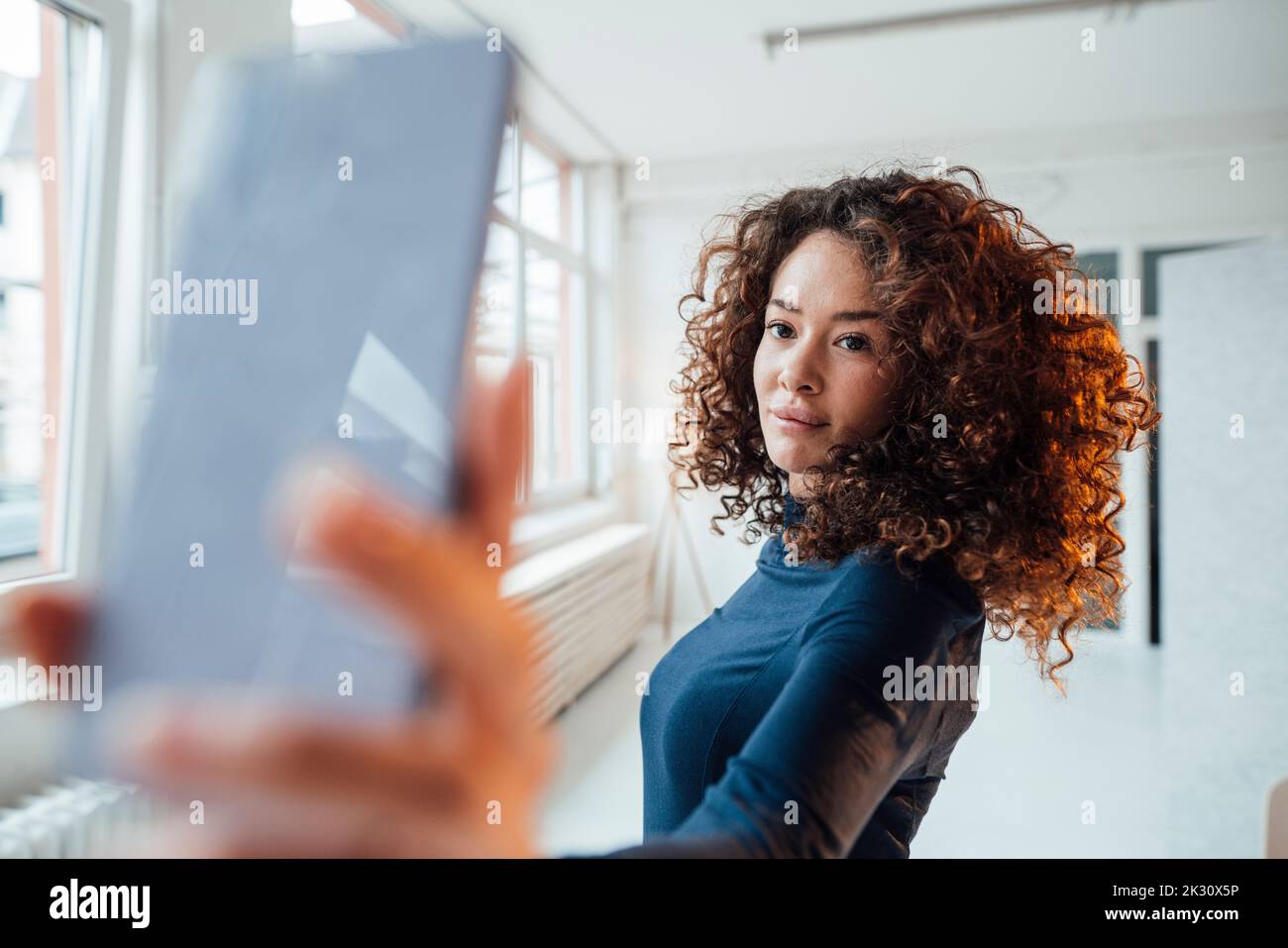 Beautiful woman with curly hair taking through mobile phone Stock Photo ...