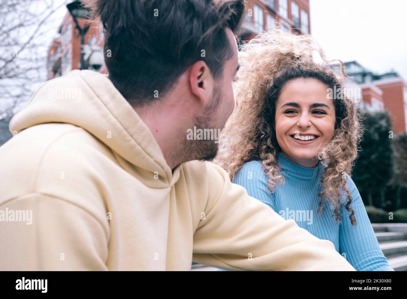 Happy young woman talking with boyfriend Stock Photo - Alamy