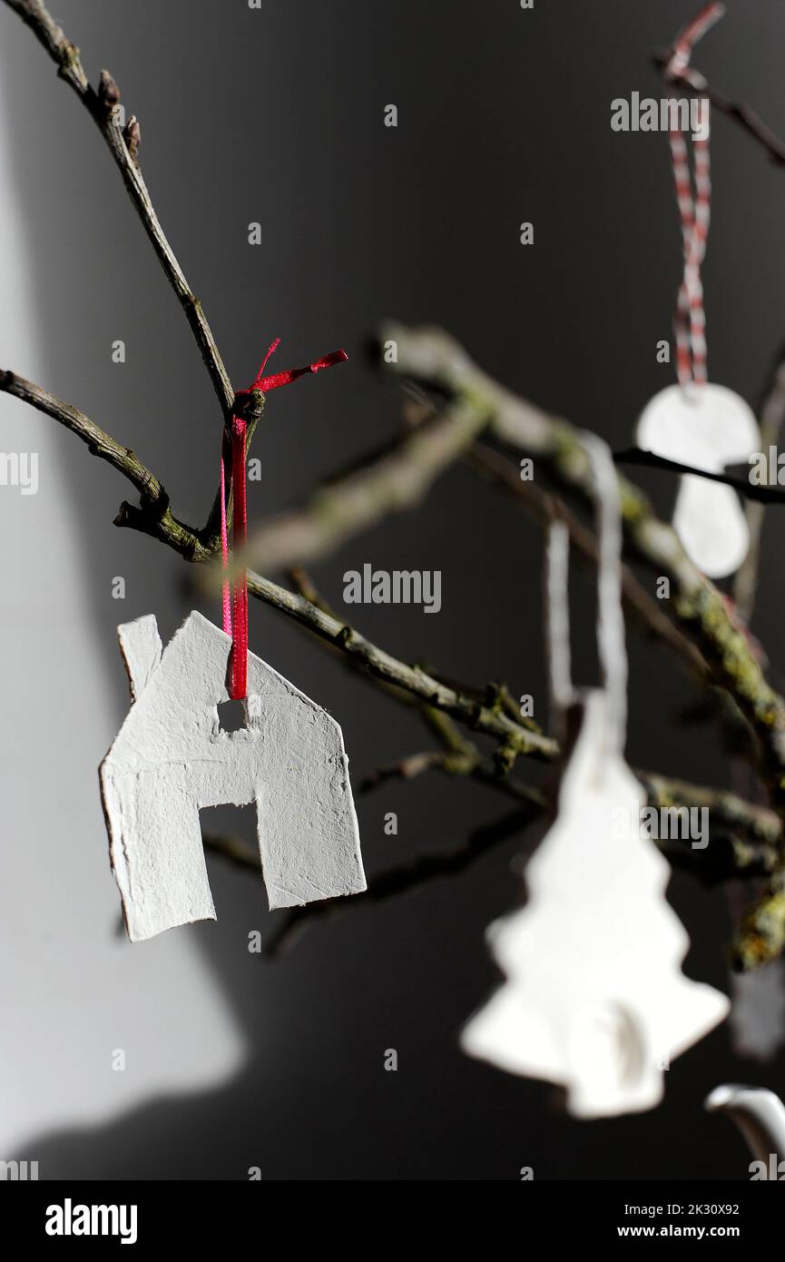 Simple house-shaped decoration hanging on twig Stock Photo - Alamy