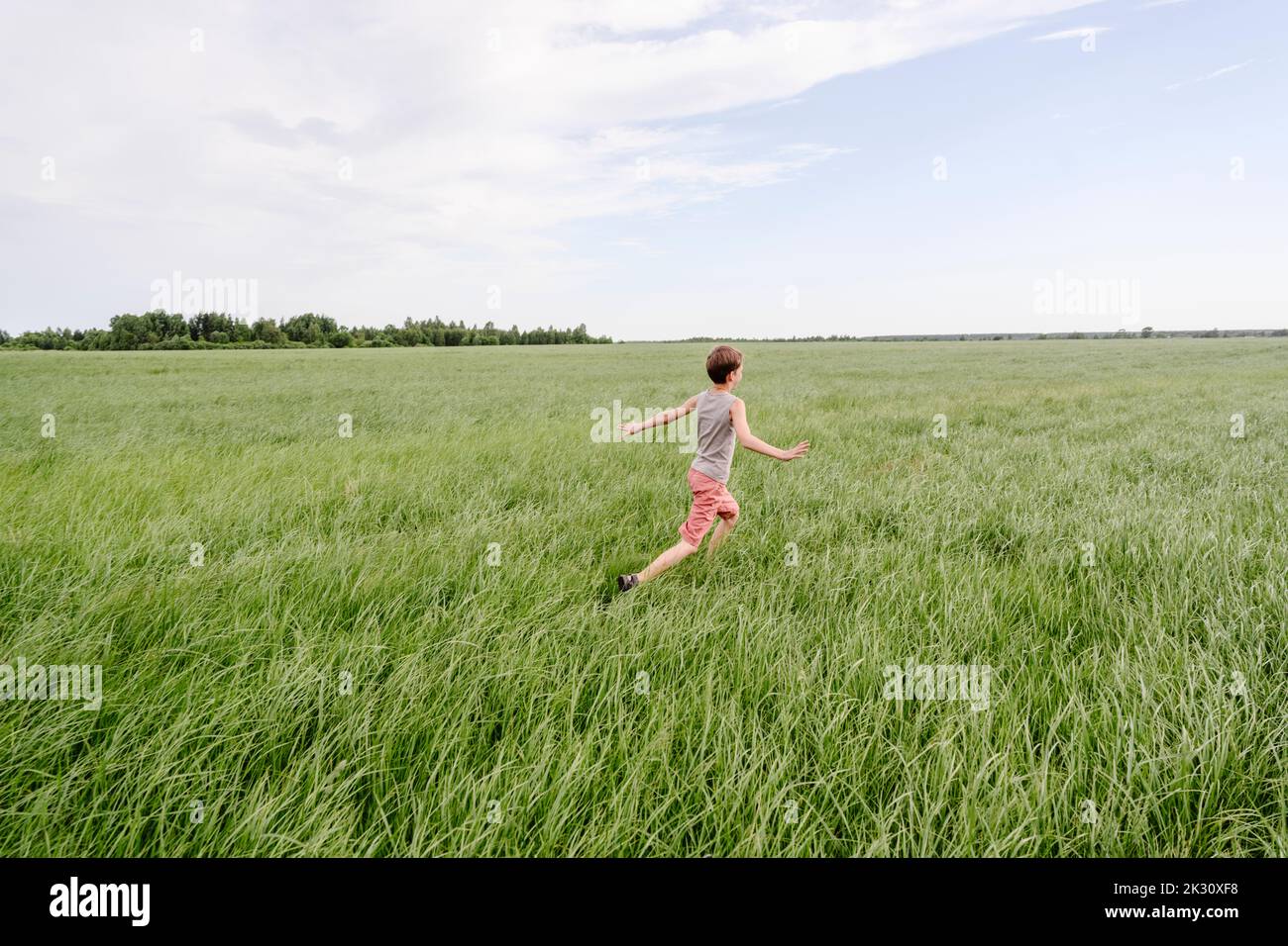 Boy running over grass hi-res stock photography and images - Alamy
