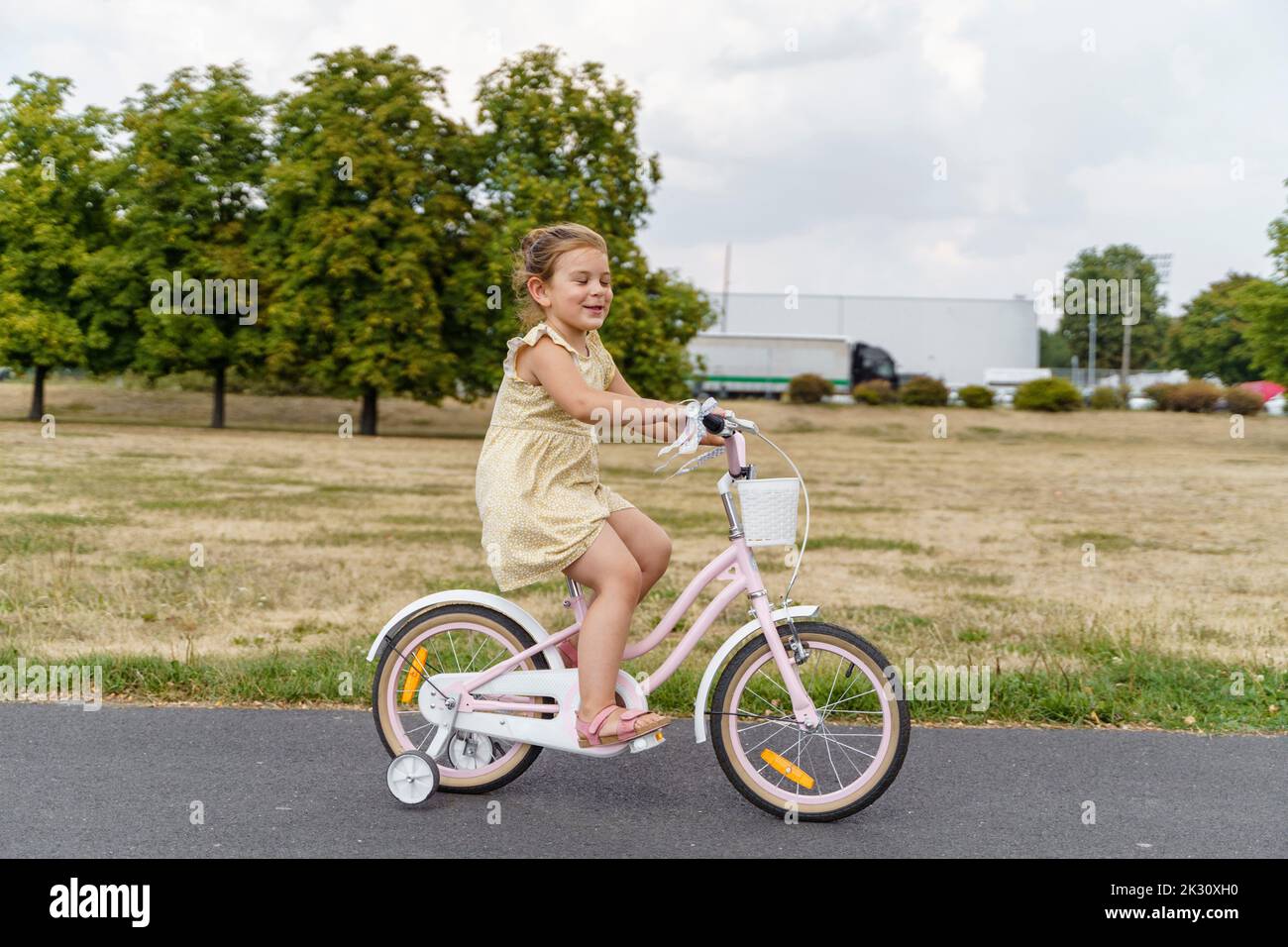 Smiling girl riding bicycle at park Stock Photo - Alamy