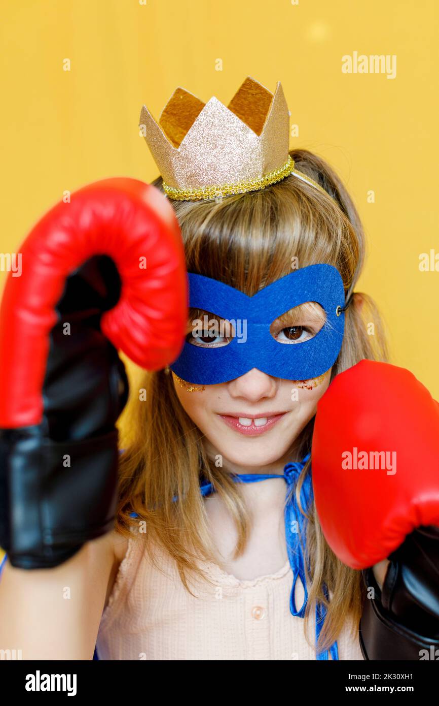 Girl wearing boxing gloves and mask against yellow background Stock ...