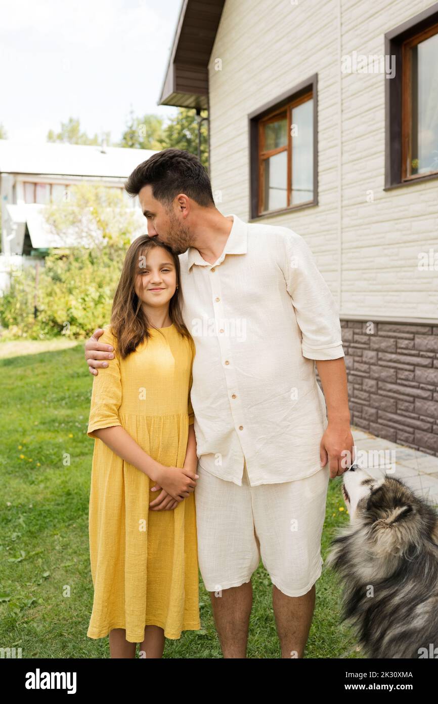 Father kissing smiling daughter by pet dog in back yard Stock Photo - Alamy