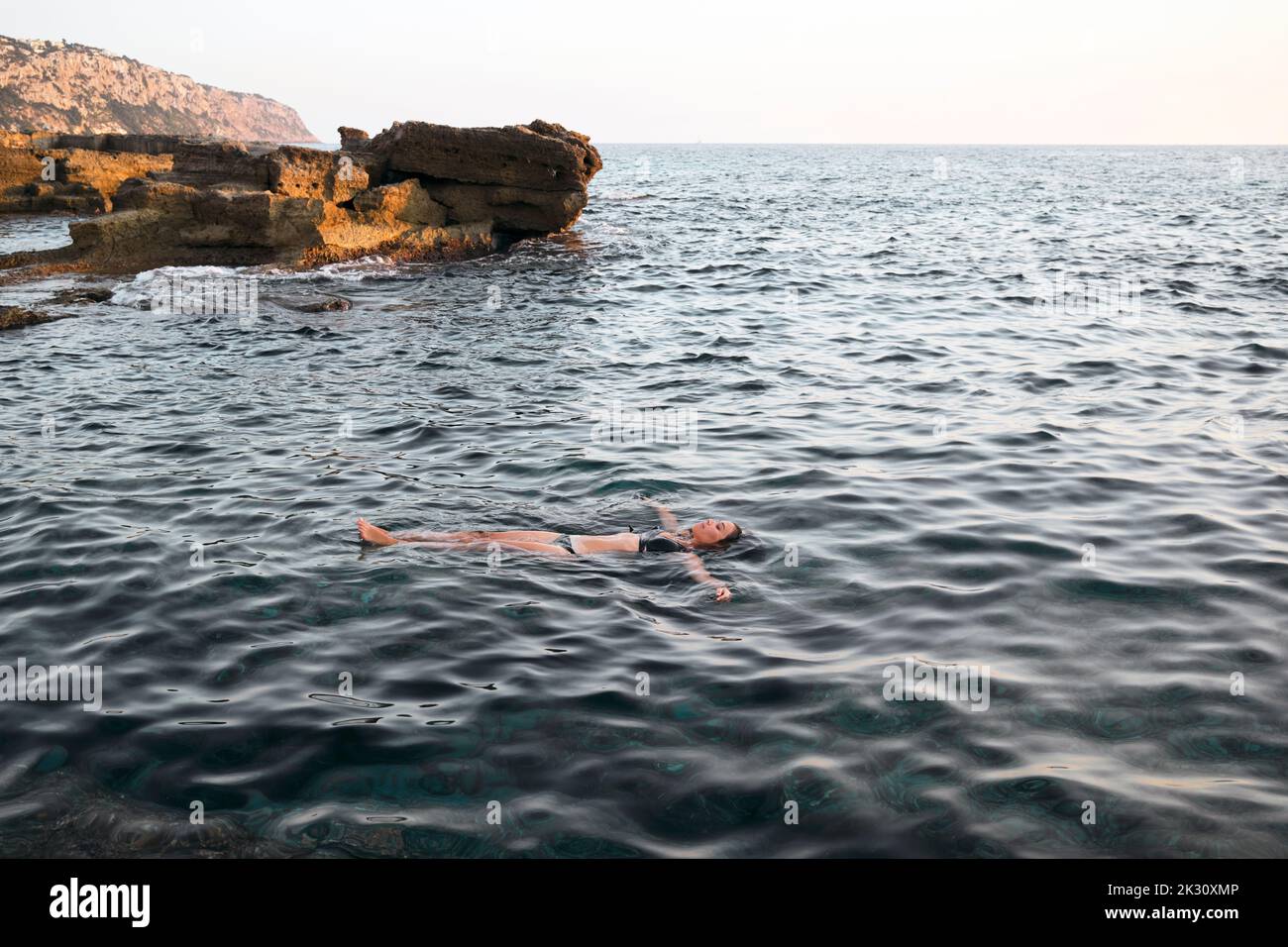 Woman floating on water sunset hi-res stock photography and images - Alamy
