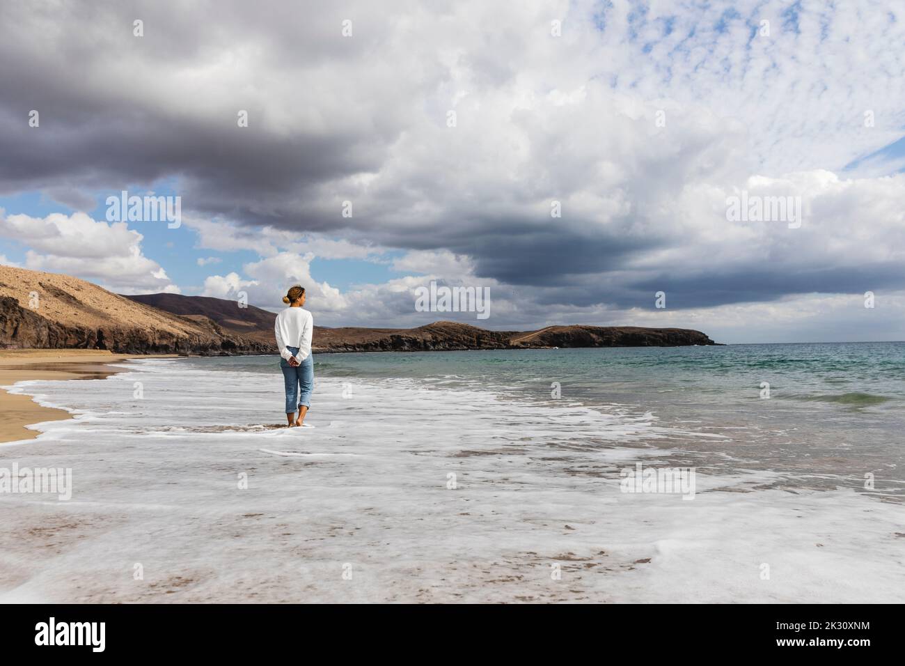 Woman walking on water at beach Stock Photo - Alamy