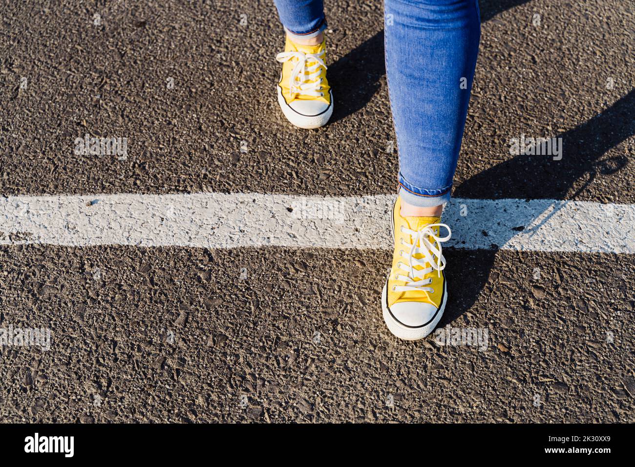 Woman stepping over white line drawn on asphalt Stock Photo - Alamy