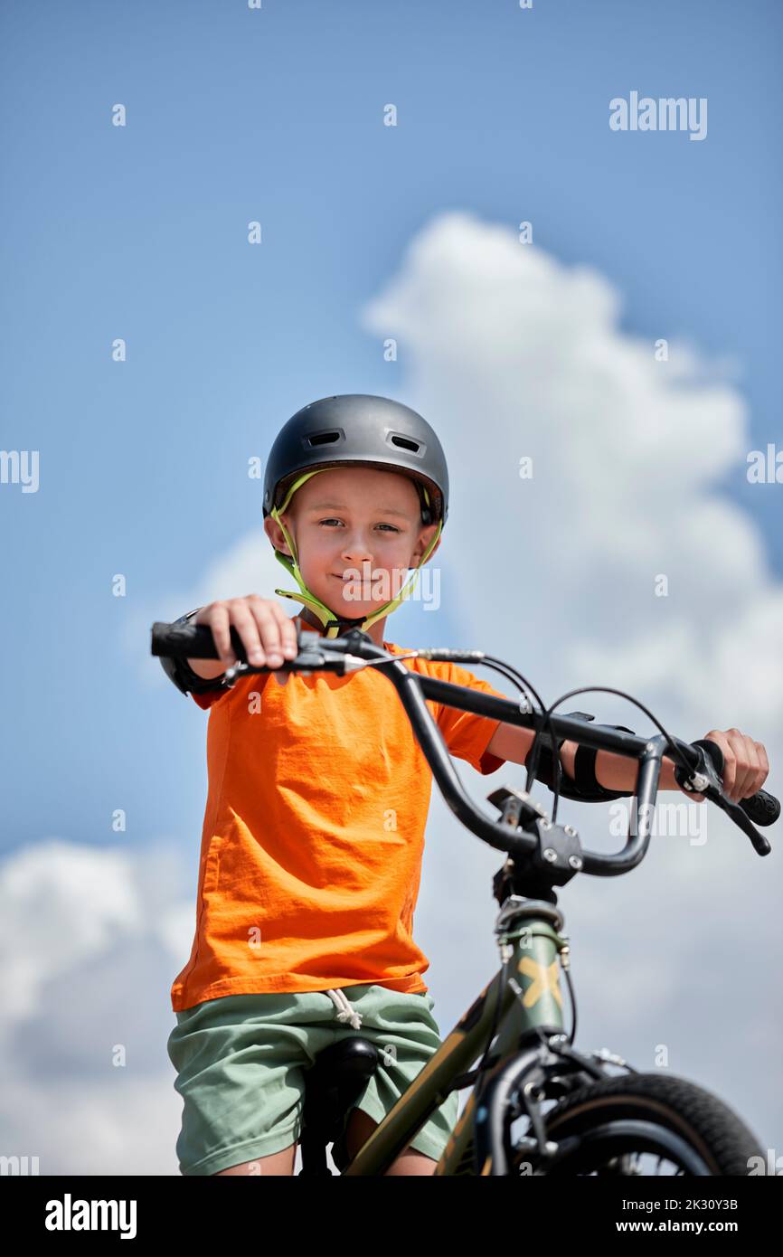 Boy wearing helmet sitting on BMX bike Stock Photo - Alamy