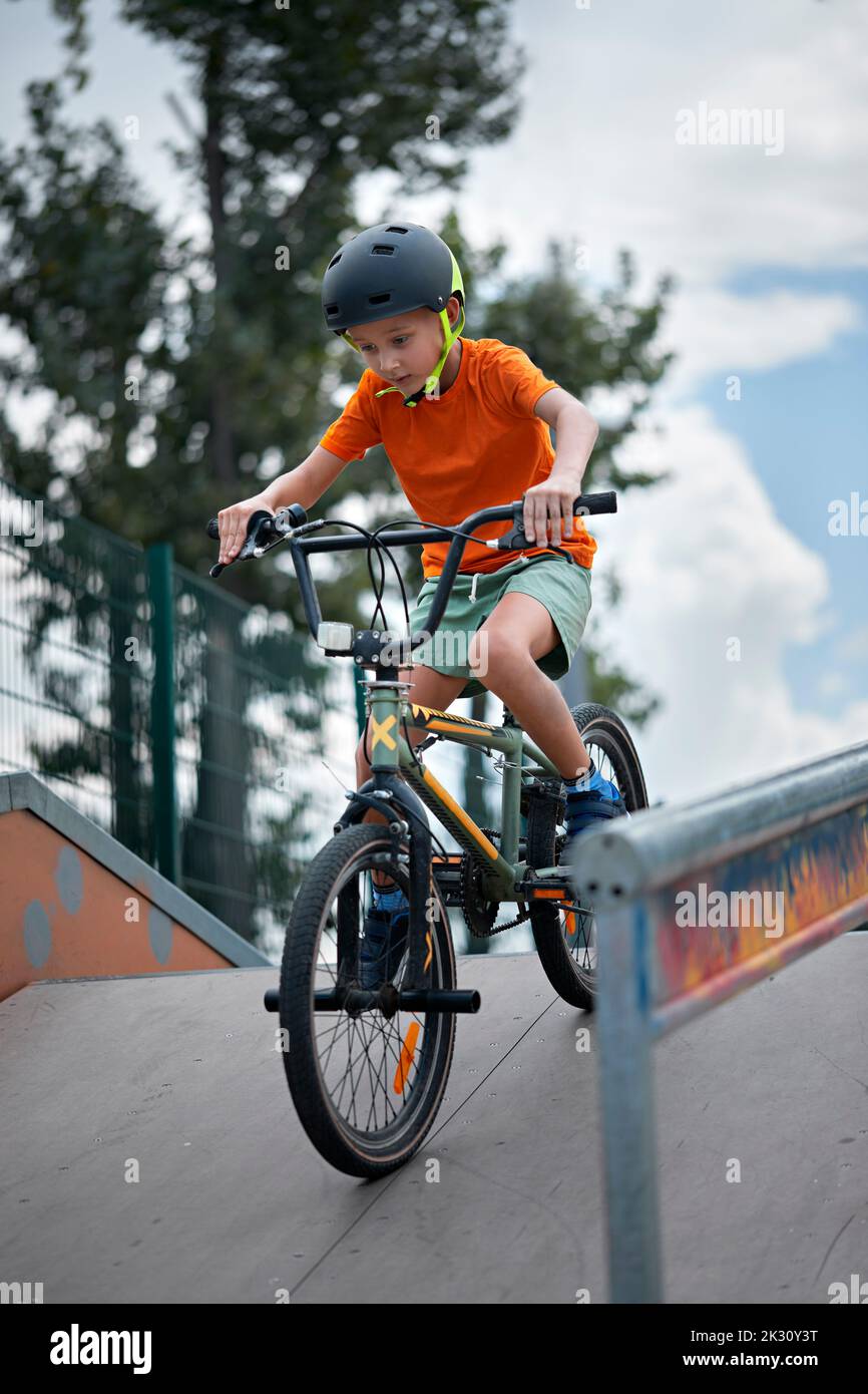 Boy practicing with BMX bike at sports ramp Stock Photo - Alamy