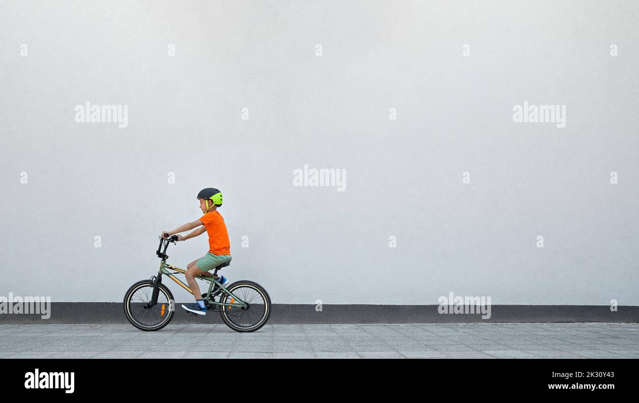 Boy riding BMX bike by white wall Stock Photo - Alamy