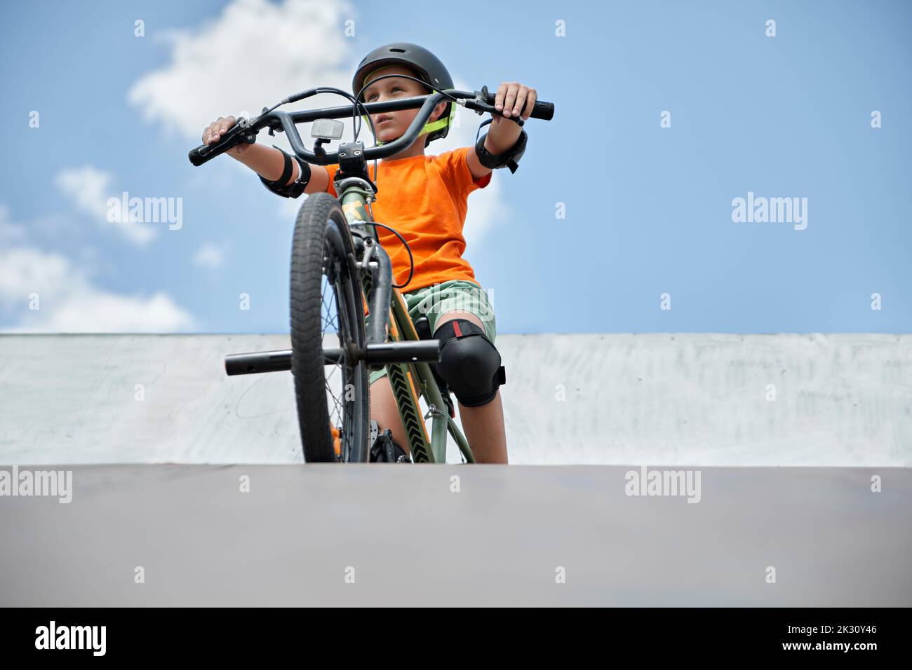 Boy sitting on BMX bike at sports ramp Stock Photo - Alamy