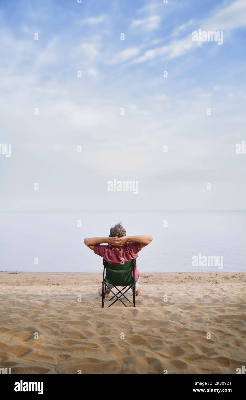 Man relaxing sitting on folding chair at beach Stock Photo - Alamy
