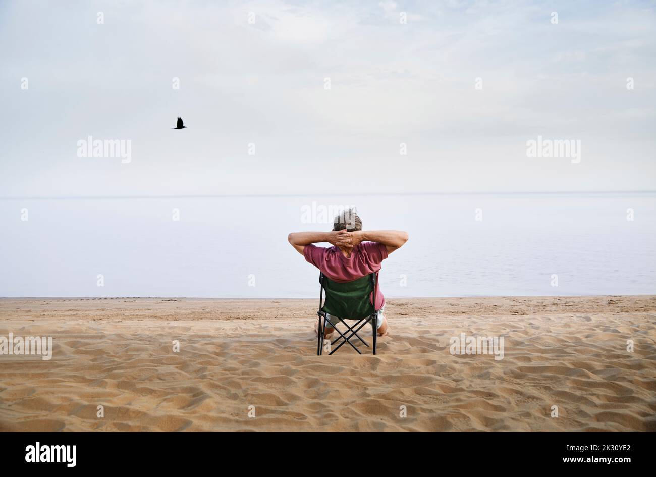 Senior man sitting on folding chair relaxing at beach Stock Photo - Alamy