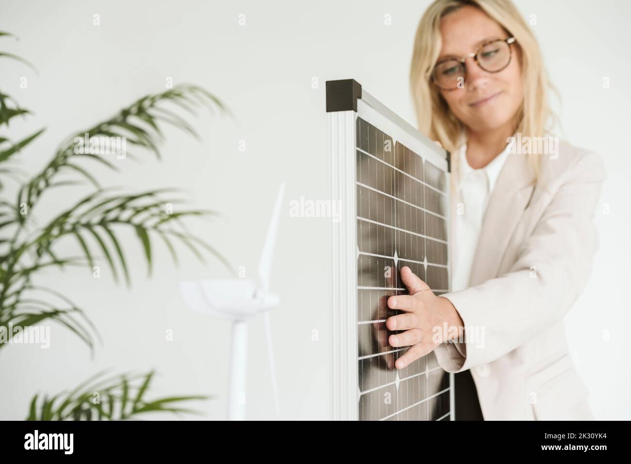 Woman touching solar panel in office Stock Photo - Alamy