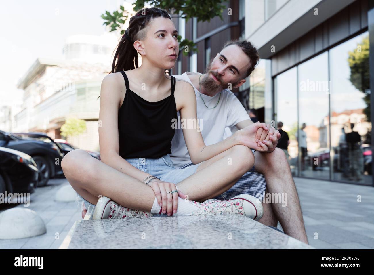 Couple talking to each other sitting on bench Stock Photo - Alamy