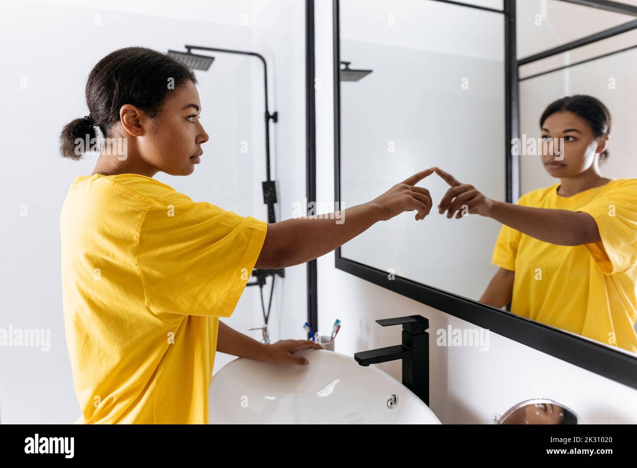 Woman pointing at herself in bathroom mirror Stock Photo - Alamy
