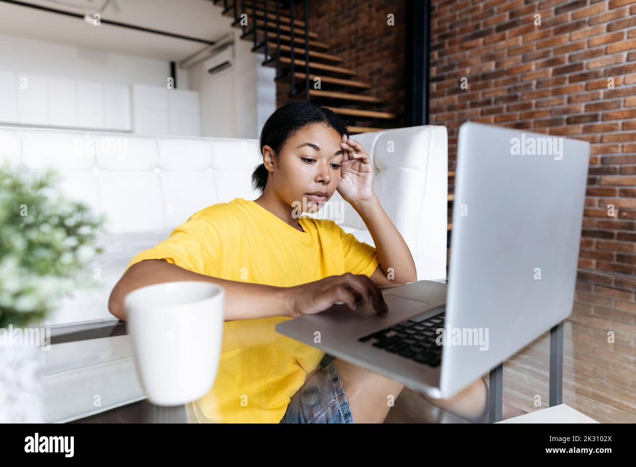 Stressed woman working on a computer in the living room Stock Photo - Alamy
