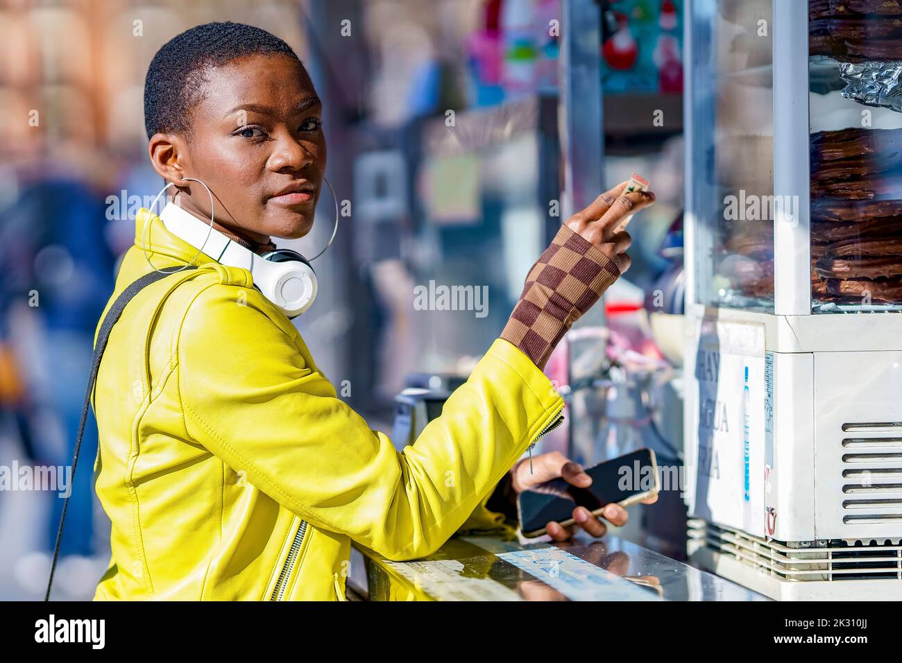 Woman wearing leather jacket standing at concession stand Stock Photo ...