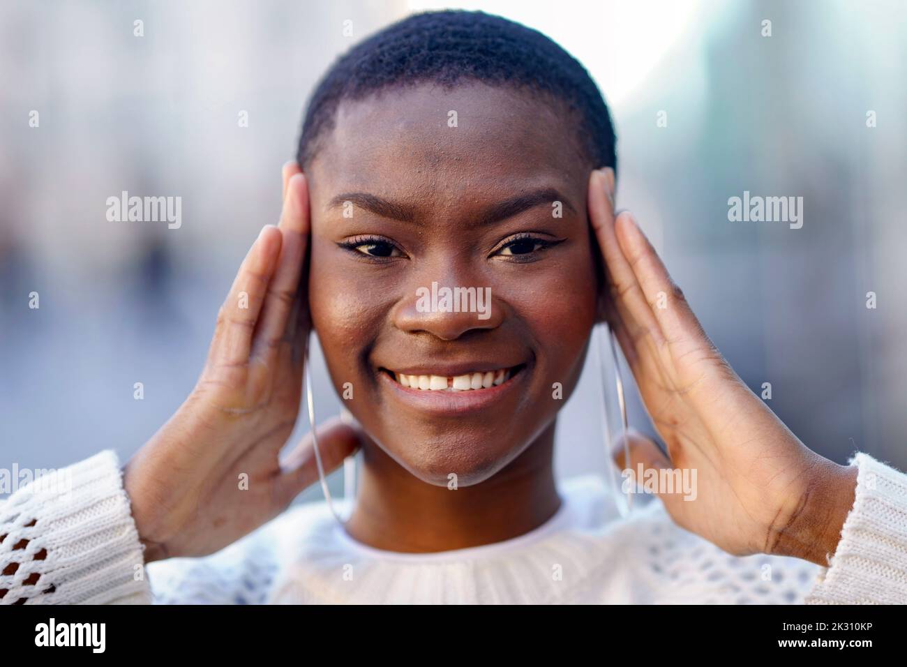 Smiling woman with gap toothed touching head Stock Photo - Alamy