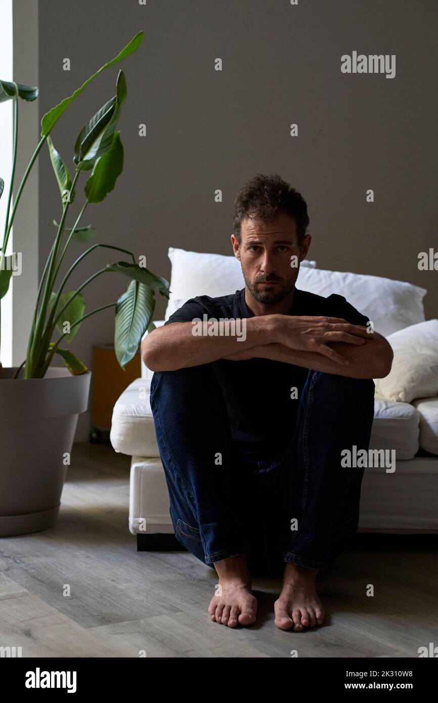 Sad man sitting on floor hi-res stock photography and images - Alamy