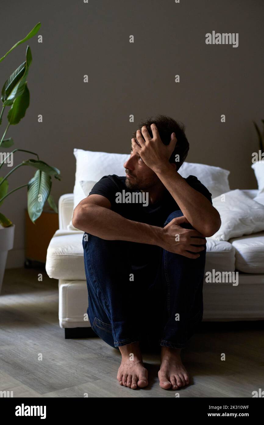 Depressed man sitting on floor Stock Photo - Alamy