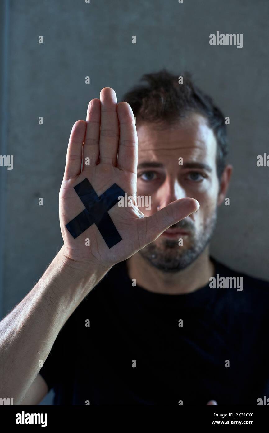 Man showing hand with cross marking in front of wall Stock Photo - Alamy
