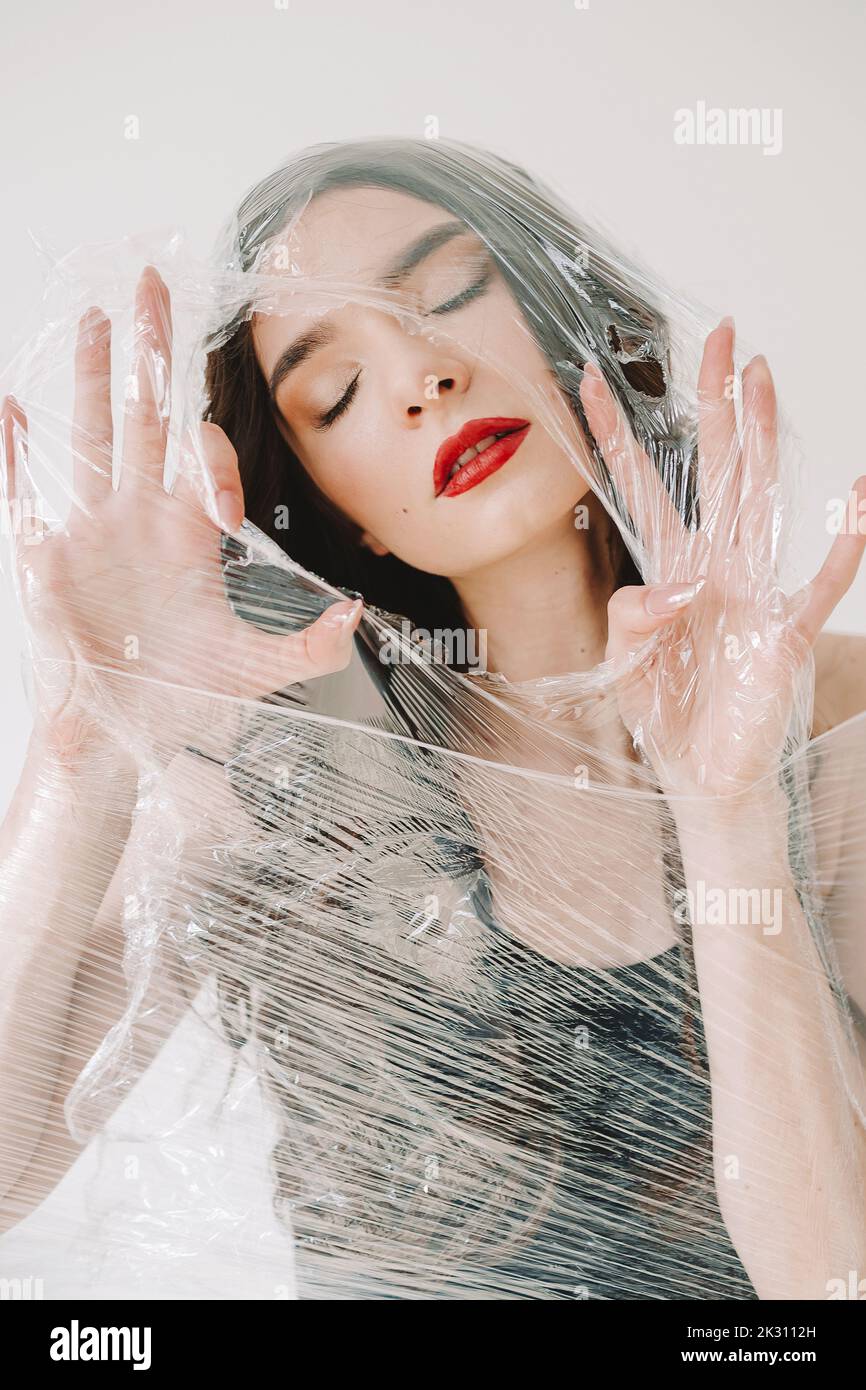 Woman breaking hole through the plastic Stock Photo - Alamy
