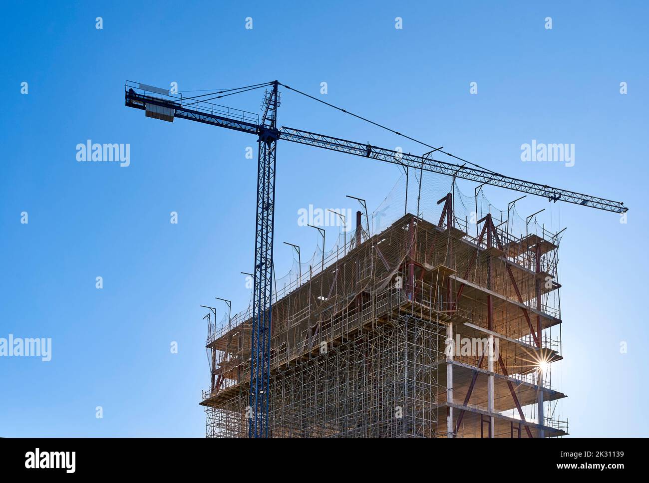 Crane standing in front of building under construction Stock Photo - Alamy