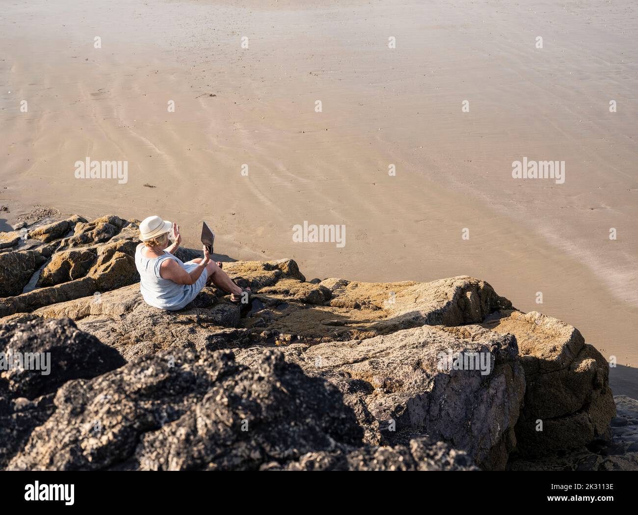 Senior woman talking on video call through tablet PC at beach Stock ...
