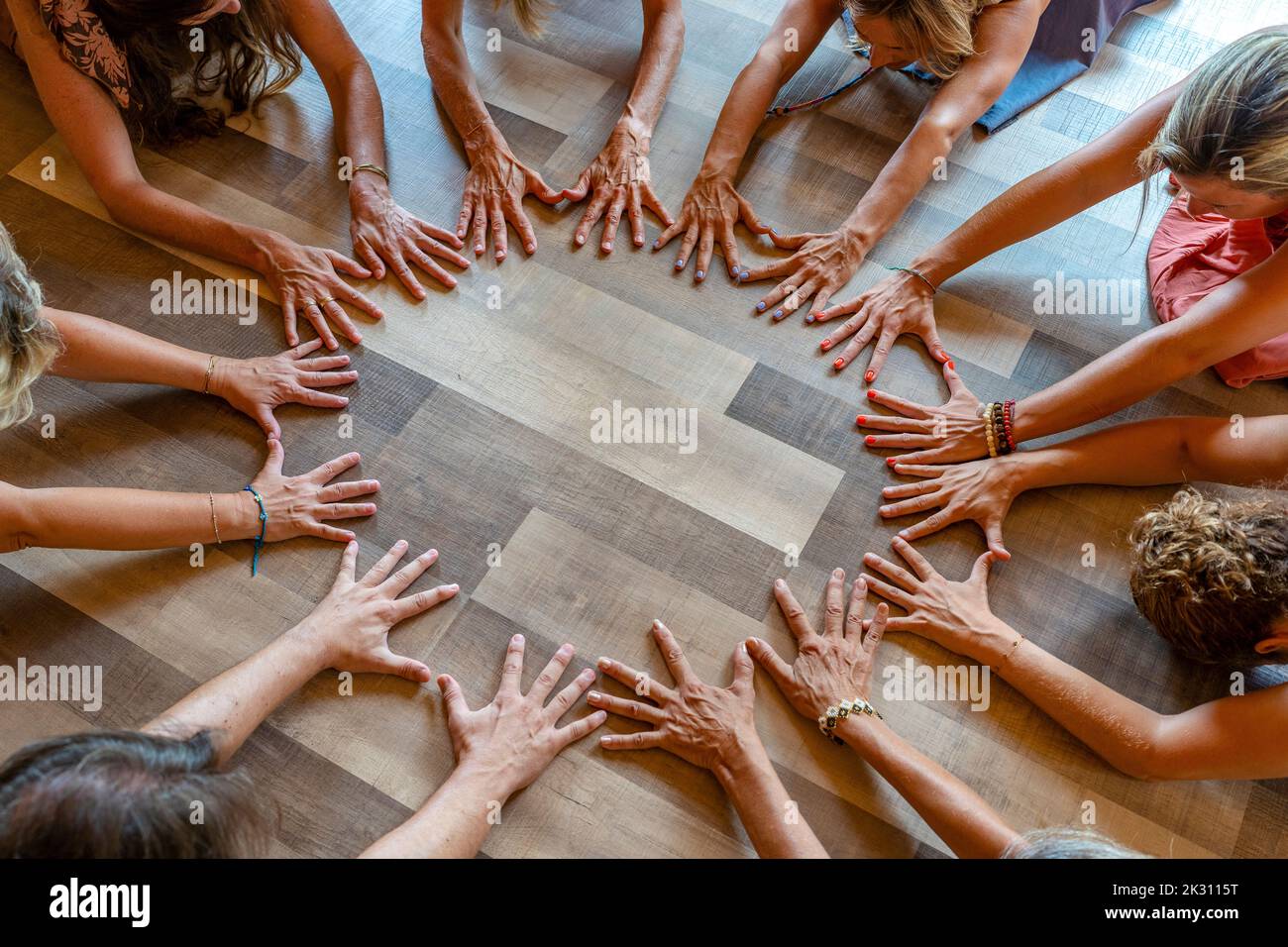 Group of friends practicing meditation with hands on floor Stock Photo ...