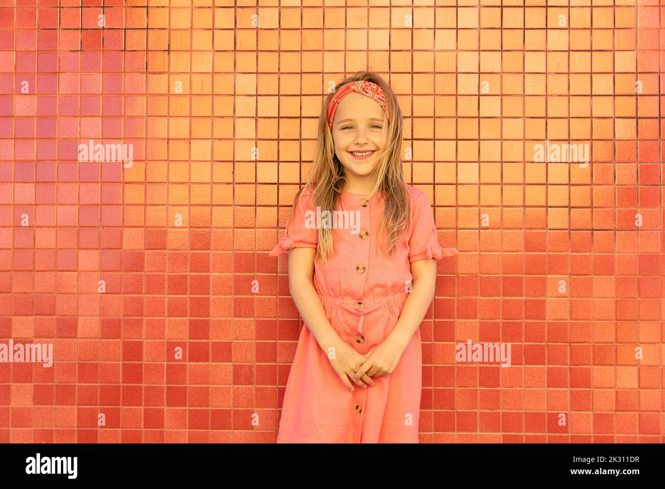 Smiling girl with standing in front of wall Stock Photo - Alamy