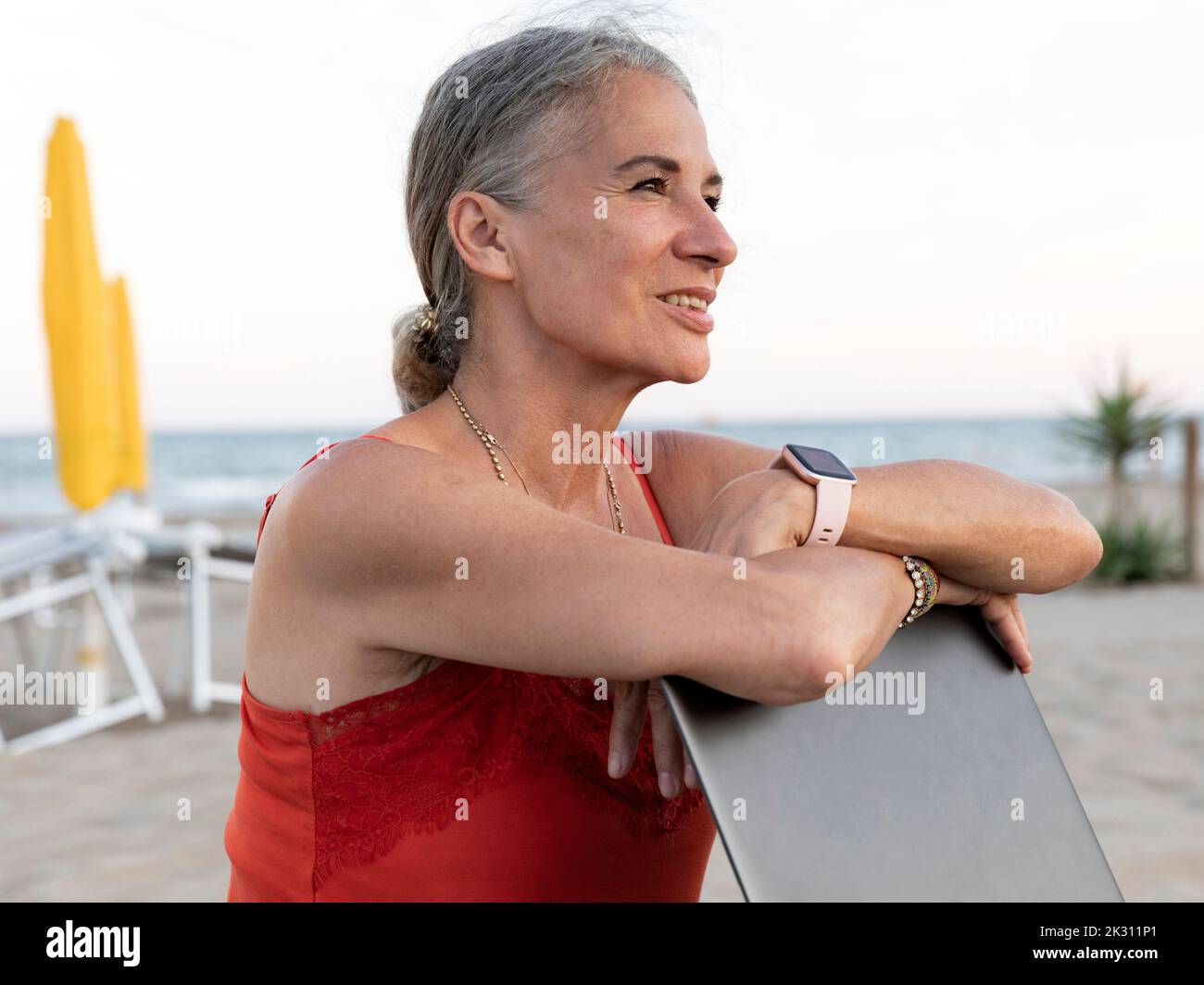 Contemplative woman sitting at beach Stock Photo - Alamy