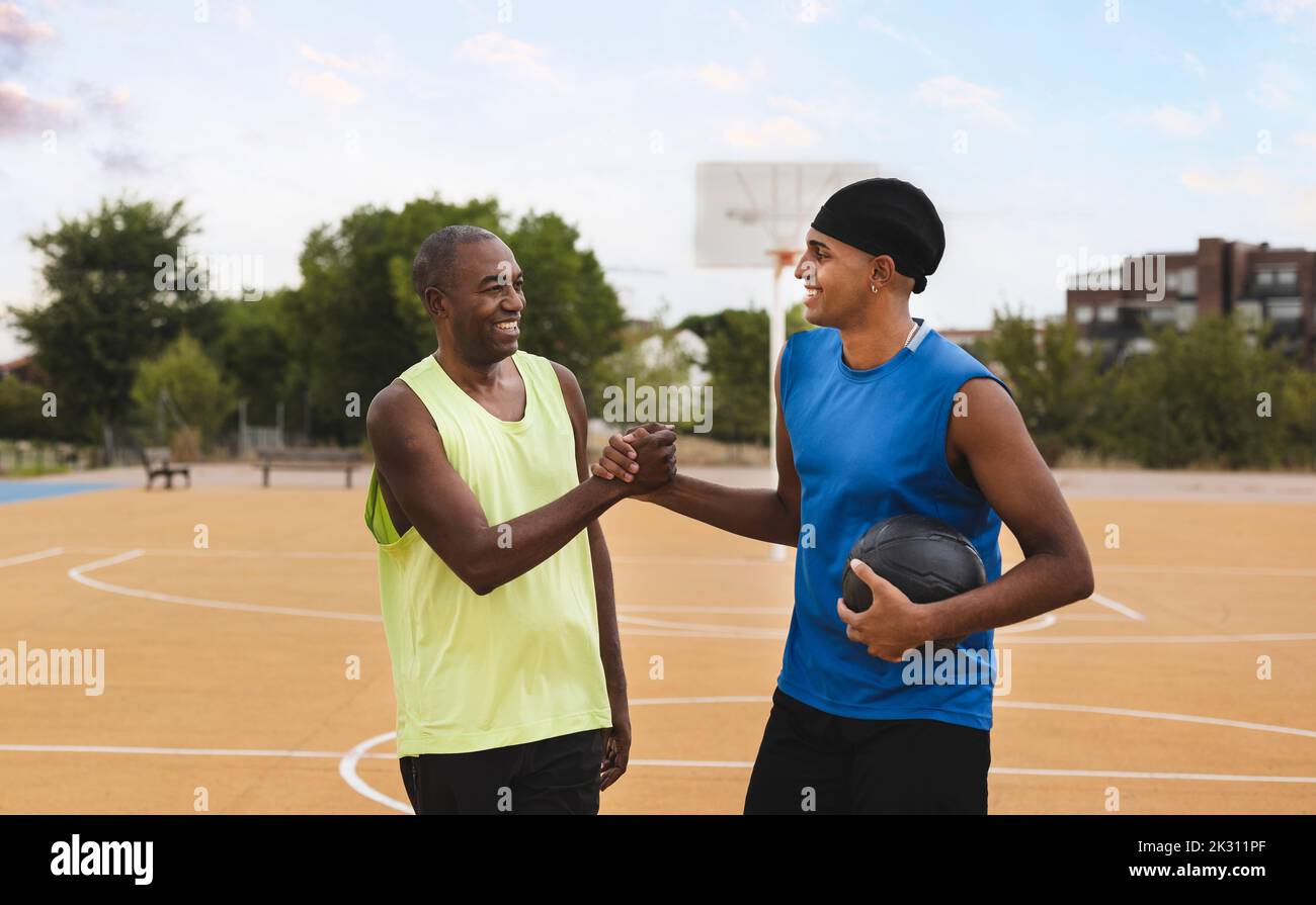 Smiling father and son doing handshake at sports court Stock Photo - Alamy